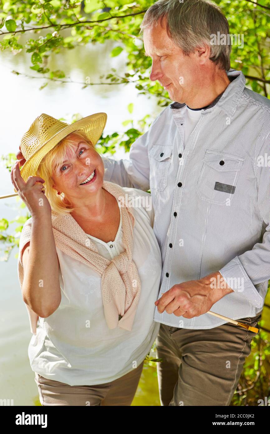 Two happy seniors stand outside in nature in summer Stock Photo - Alamy