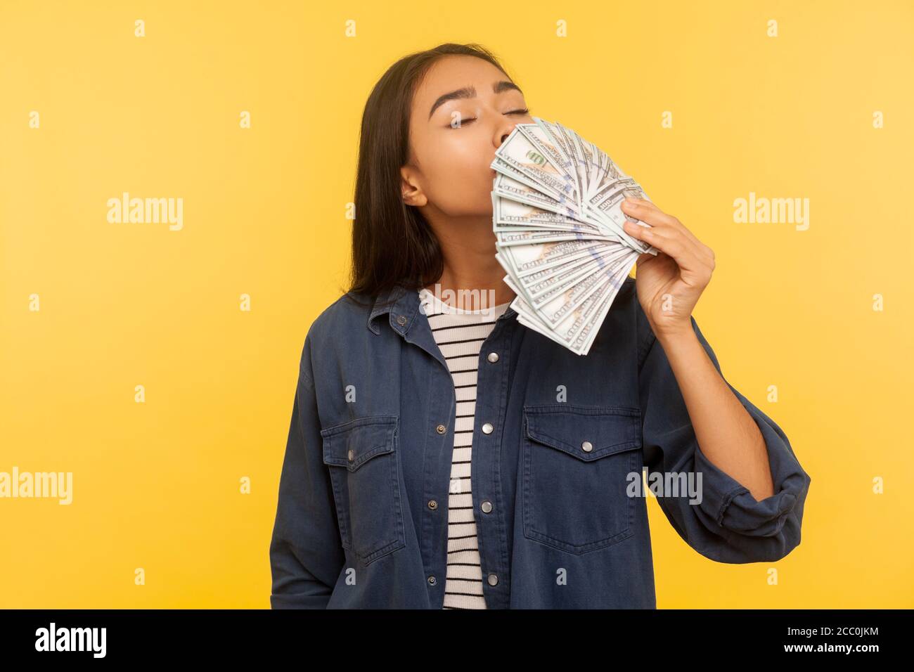 Greedy for money. Portrait of avaricious rich girl in denim shirt ...