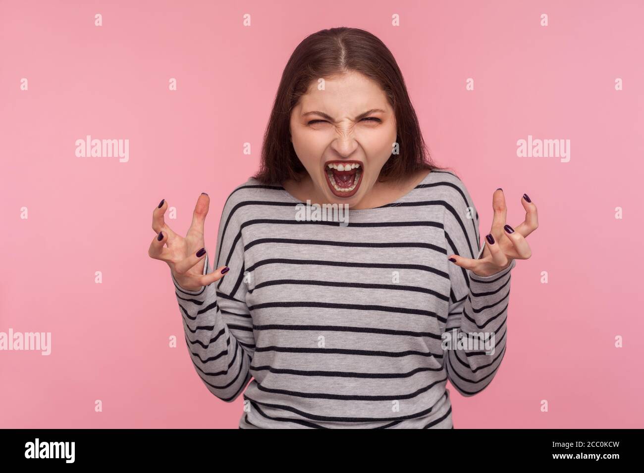 Hate this! Portrait of crazy aggressive woman in striped sweatshirt ...