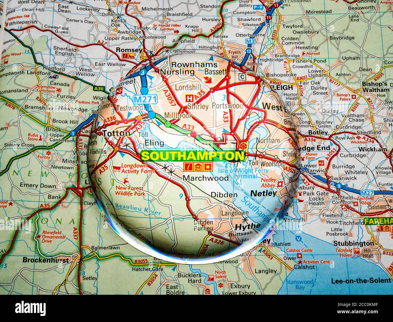 Closeup of a dome shaped magnifying glass over a page of a British road ...
