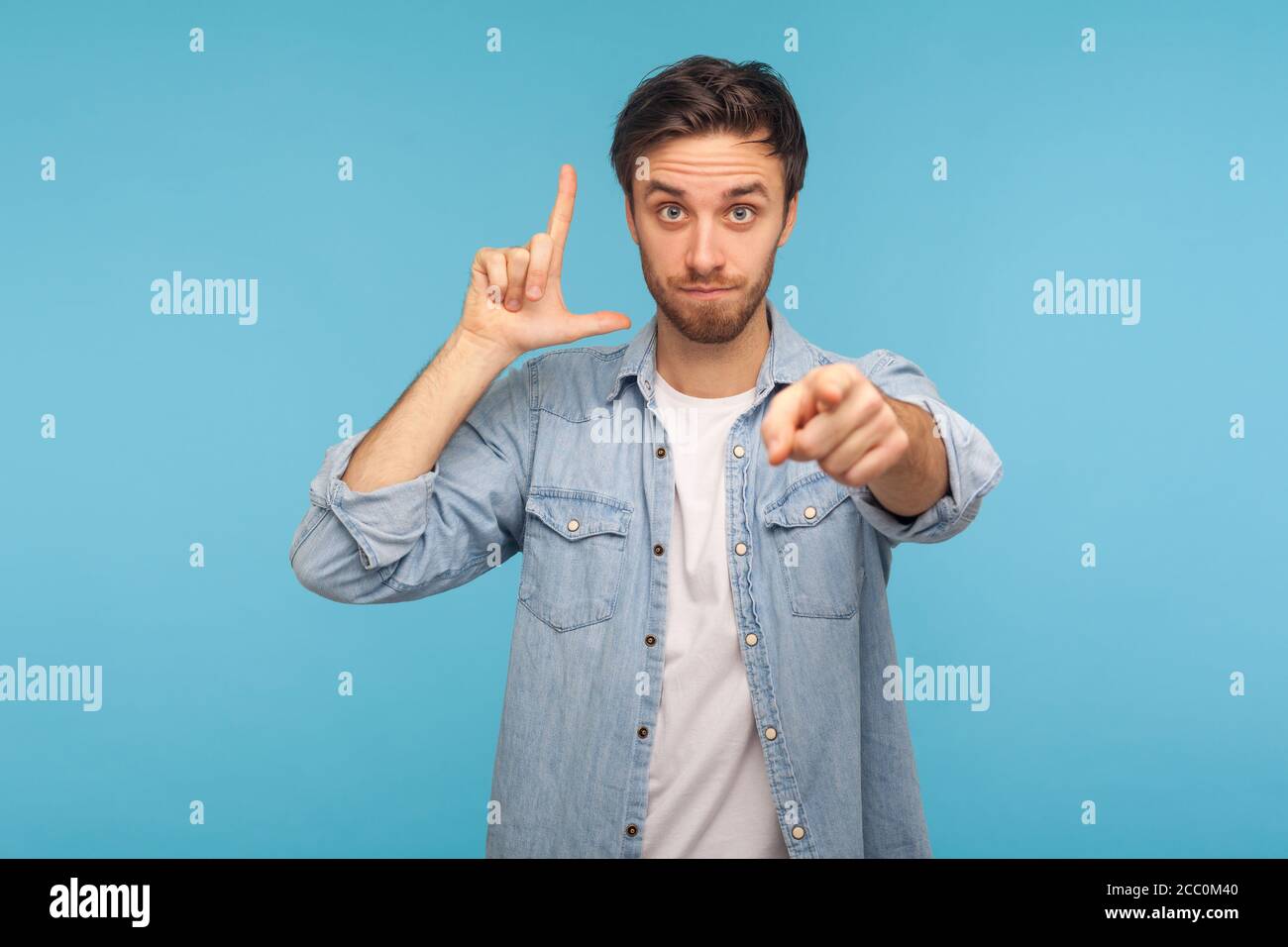 Hey, you failed! Portrait of man in worker denim shirt showing loser ...