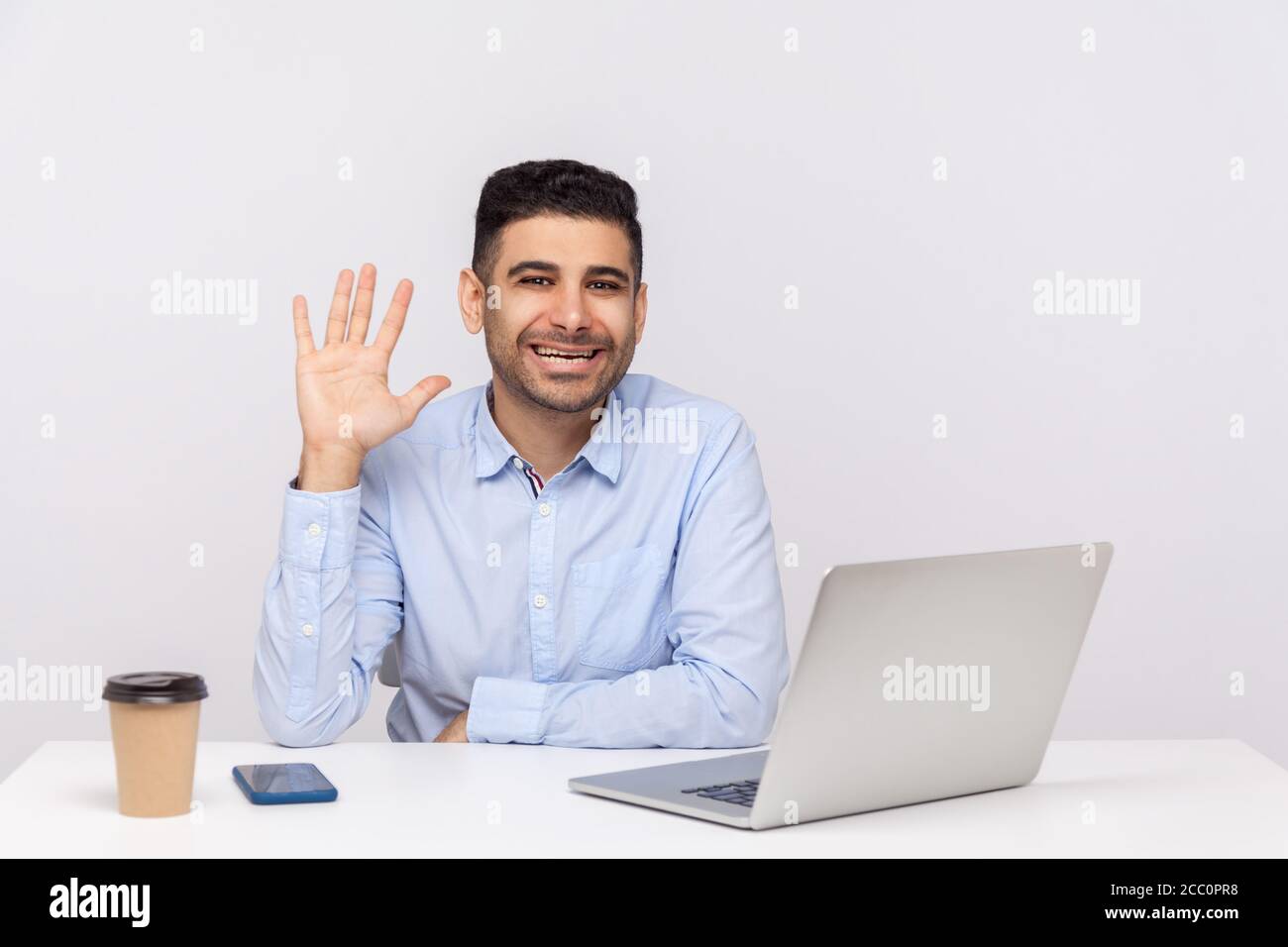 Hi! Friendly happy man employee sitting office workplace with laptop on ...
