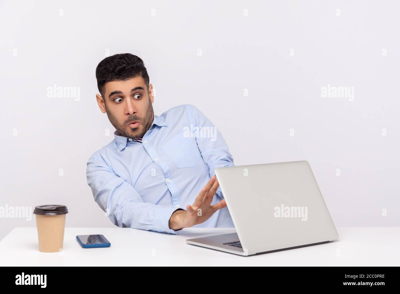 Scared frightened man employee sitting office workplace, showing stop ...