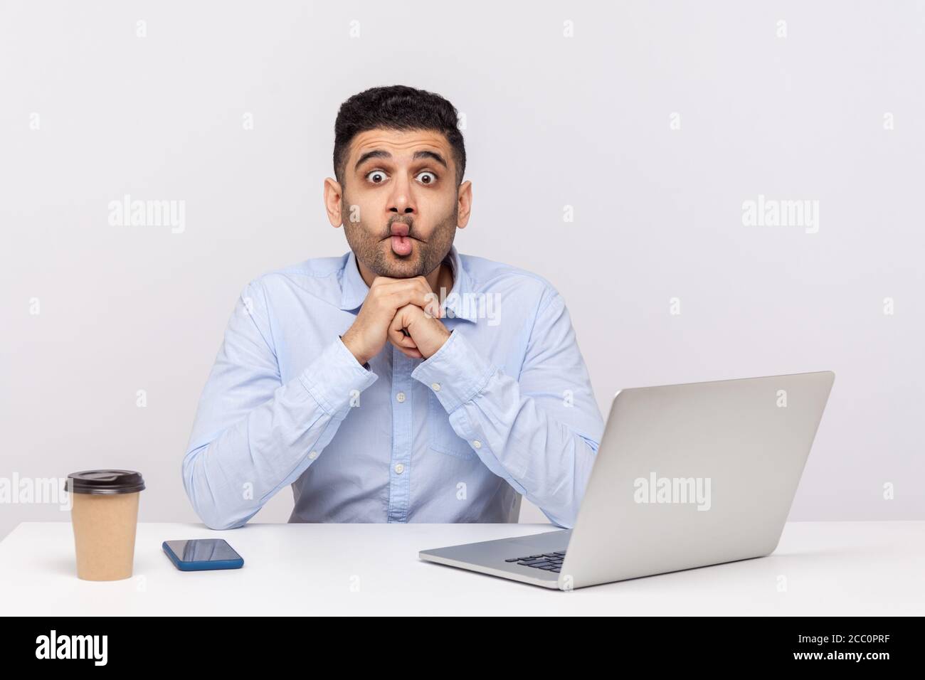Funny comical amazed man employee sitting office workplace with laptop ...