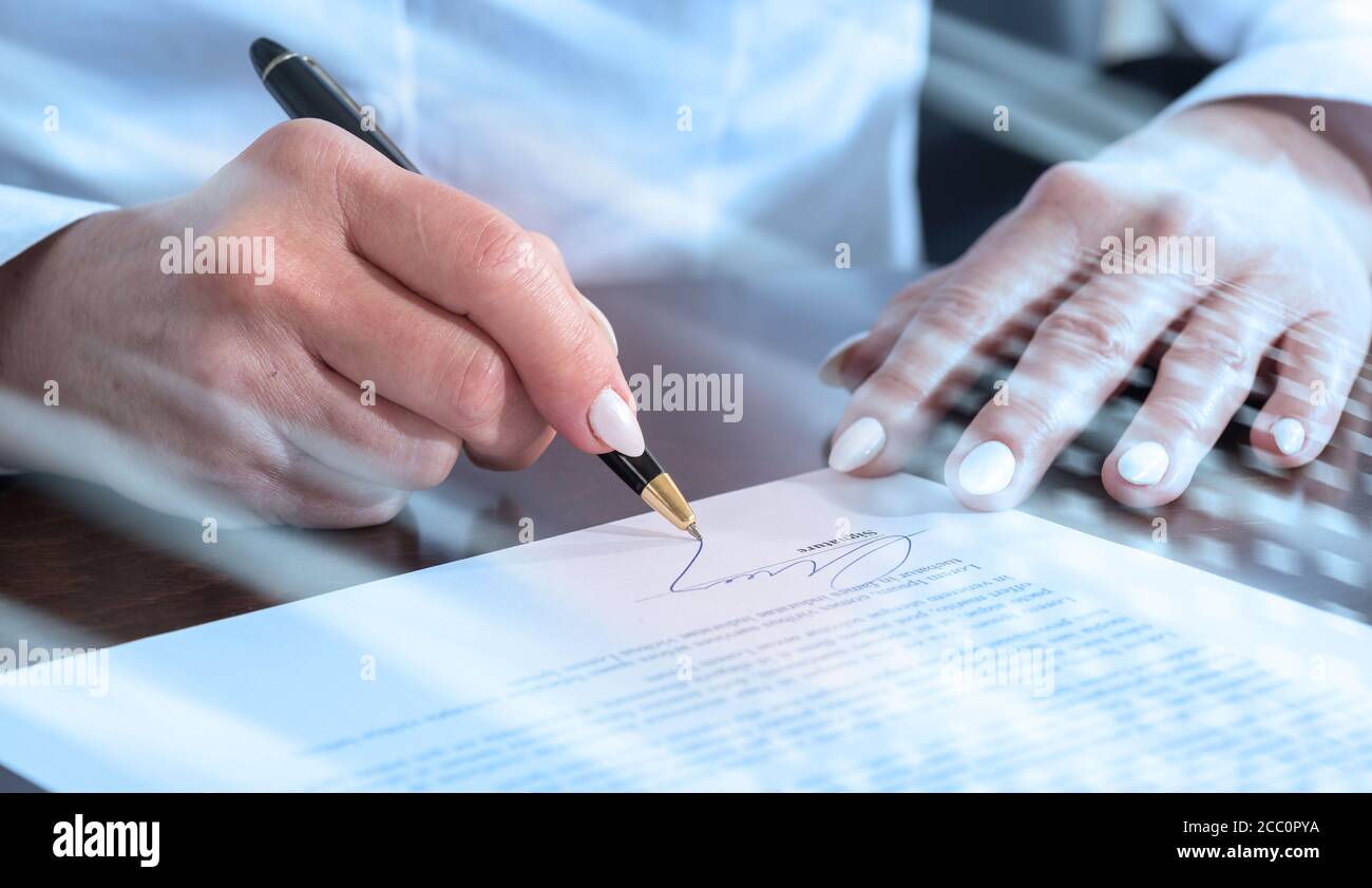 Woman signing a contract; light effect Stock Photo - Alamy