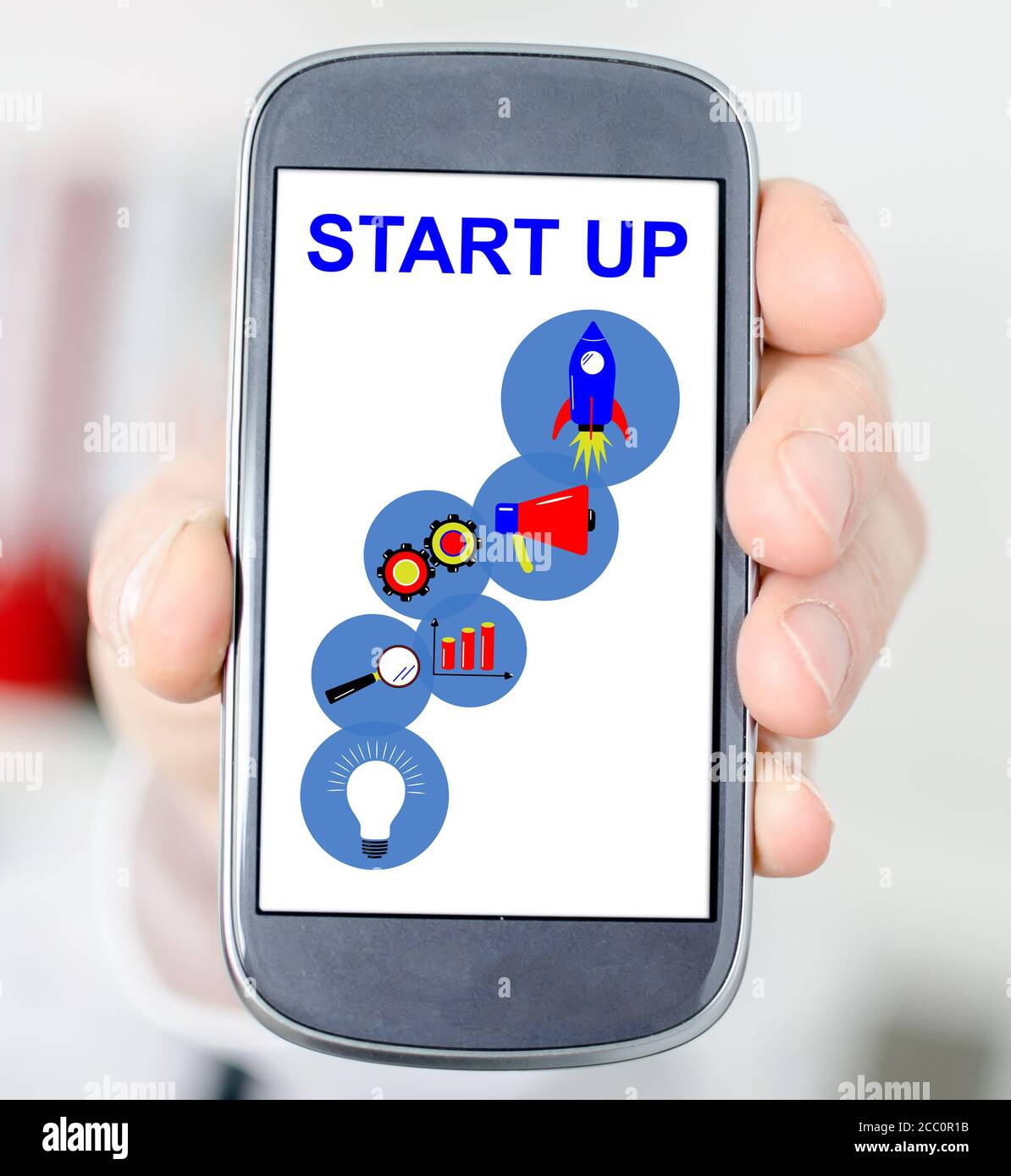 Hand holding a smartphone with start up concept Stock Photo - Alamy