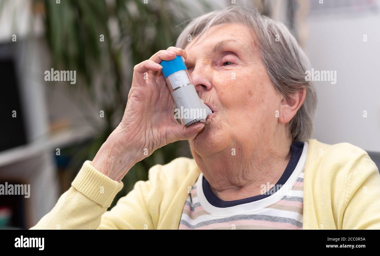 Elderly woman using an asthma inhaler Stock Photo - Alamy