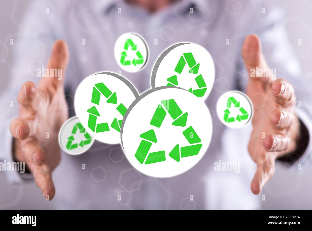 Recycling concept between hands of a man in background Stock Photo - Alamy