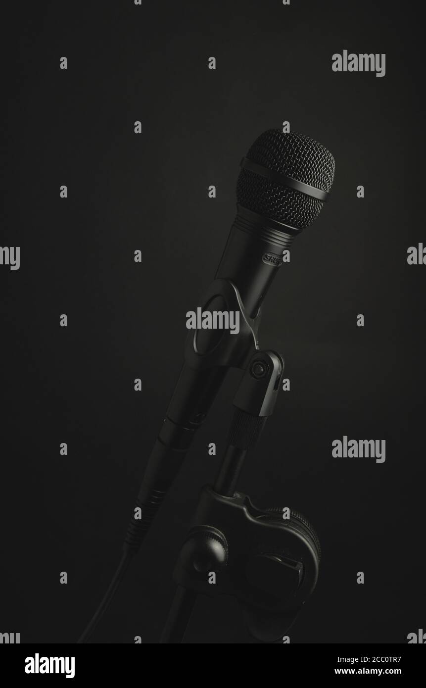 Vertical closeup shot of a black microphone on a black background Stock ...