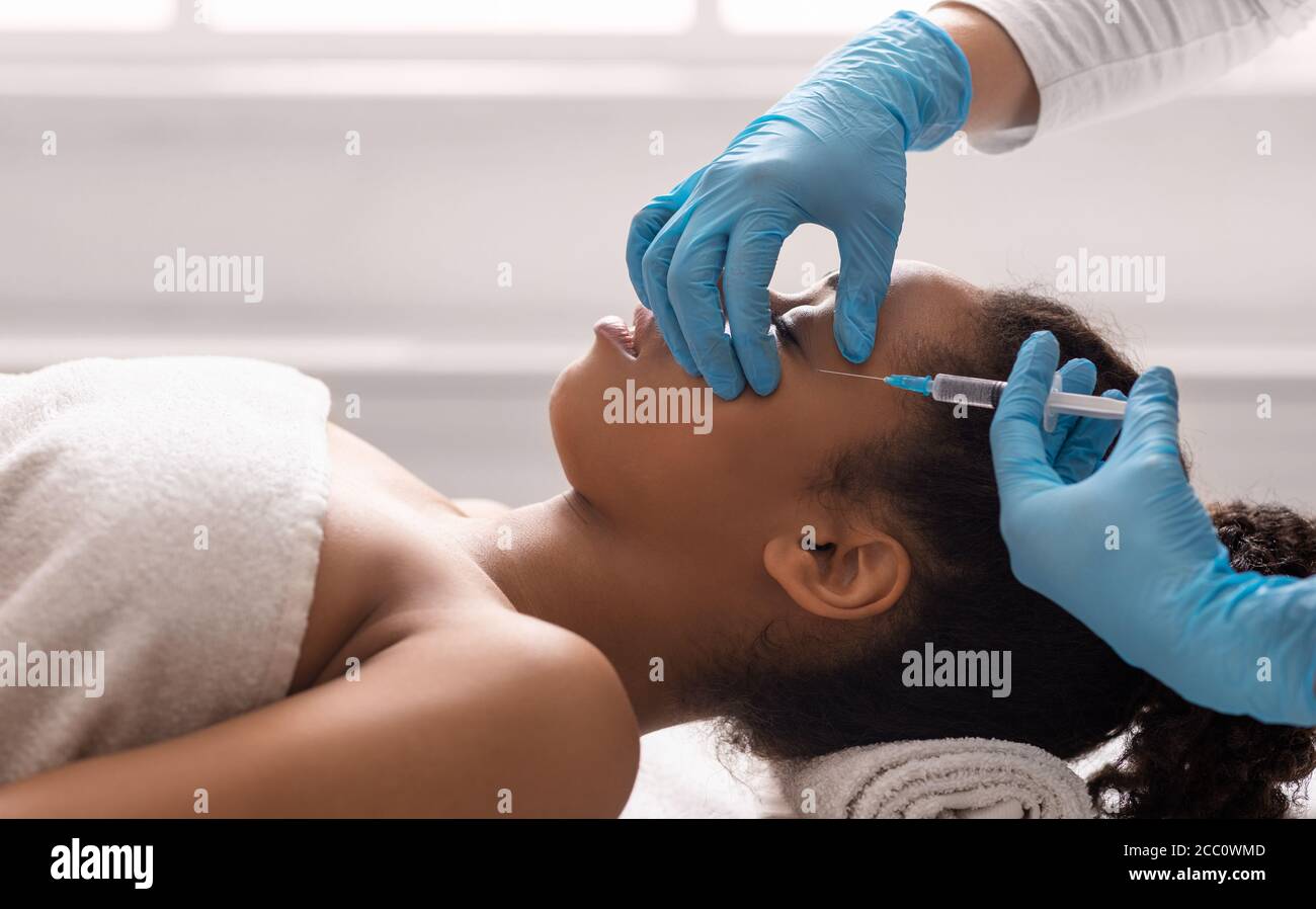 African american woman getting eye filling injection at salon Stock ...