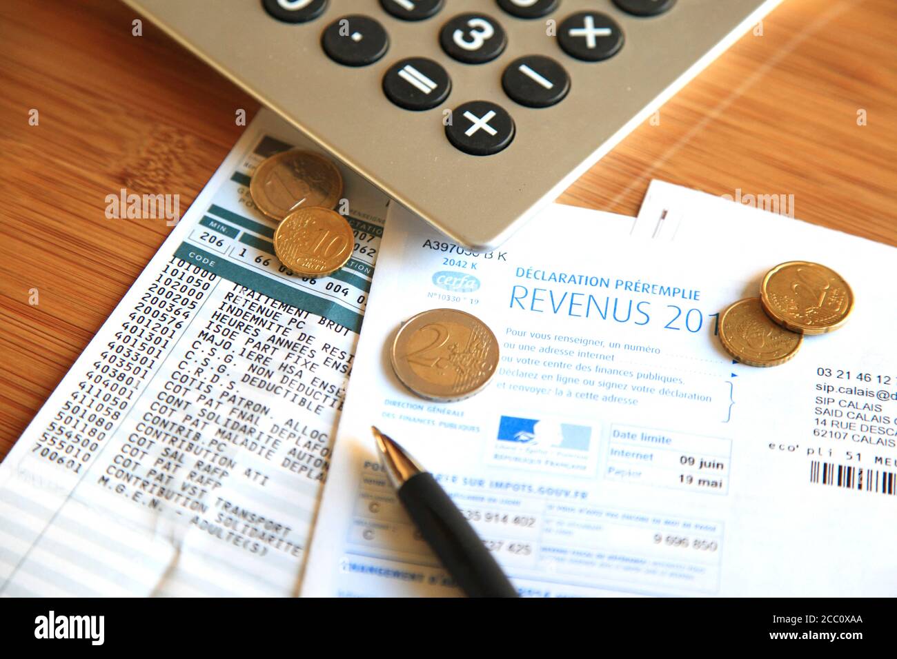 Still life including an income tax return, a calculator, a pay slip and ...
