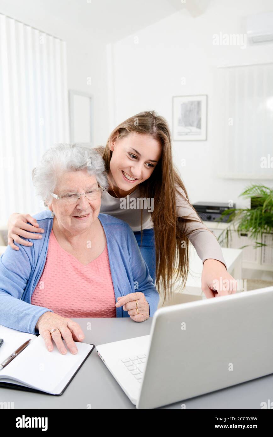 Young woman helping old senior woman doing paperwork and administrative ...