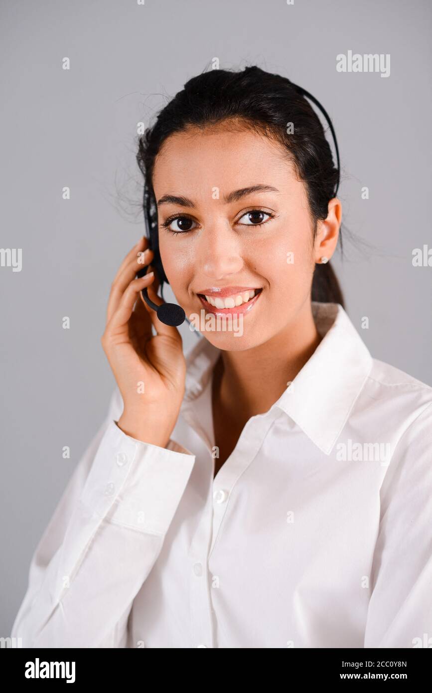 isolated portrait of cheerful young brunette woman working as telephone ...