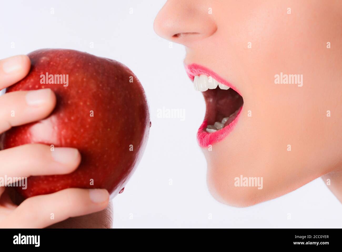 Close up of beautiful young woman mouth biting a red apple Stock Photo ...