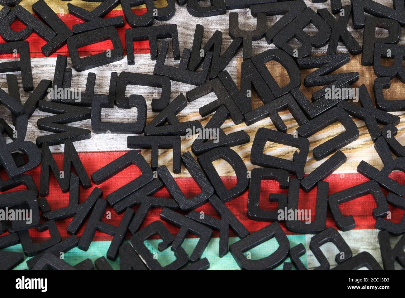 Closeup of black wooden letters on a colorful textured surface Stock ...