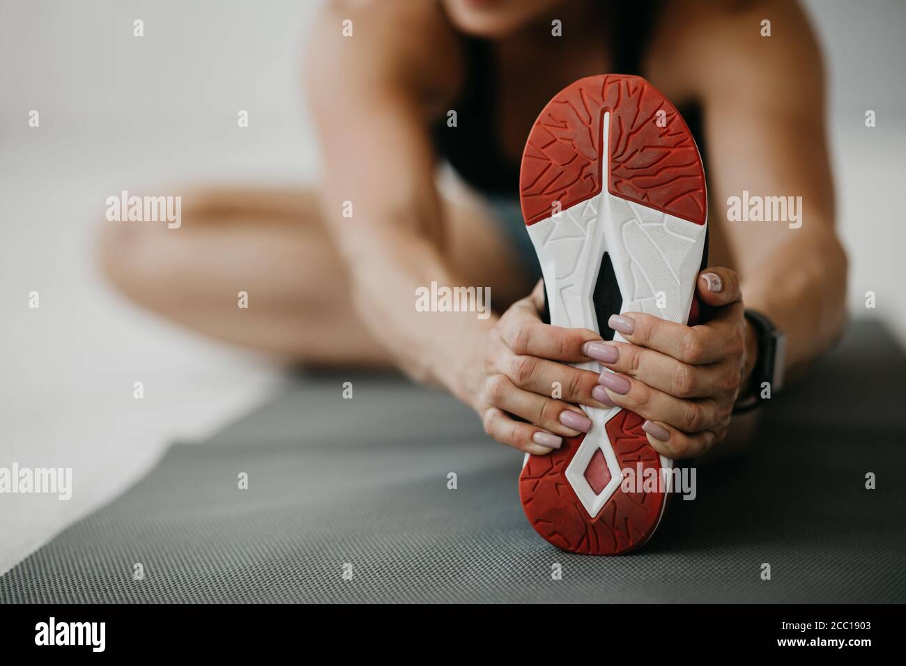 Woman in black sportswear with fitness tracker doing gymnastic and ...