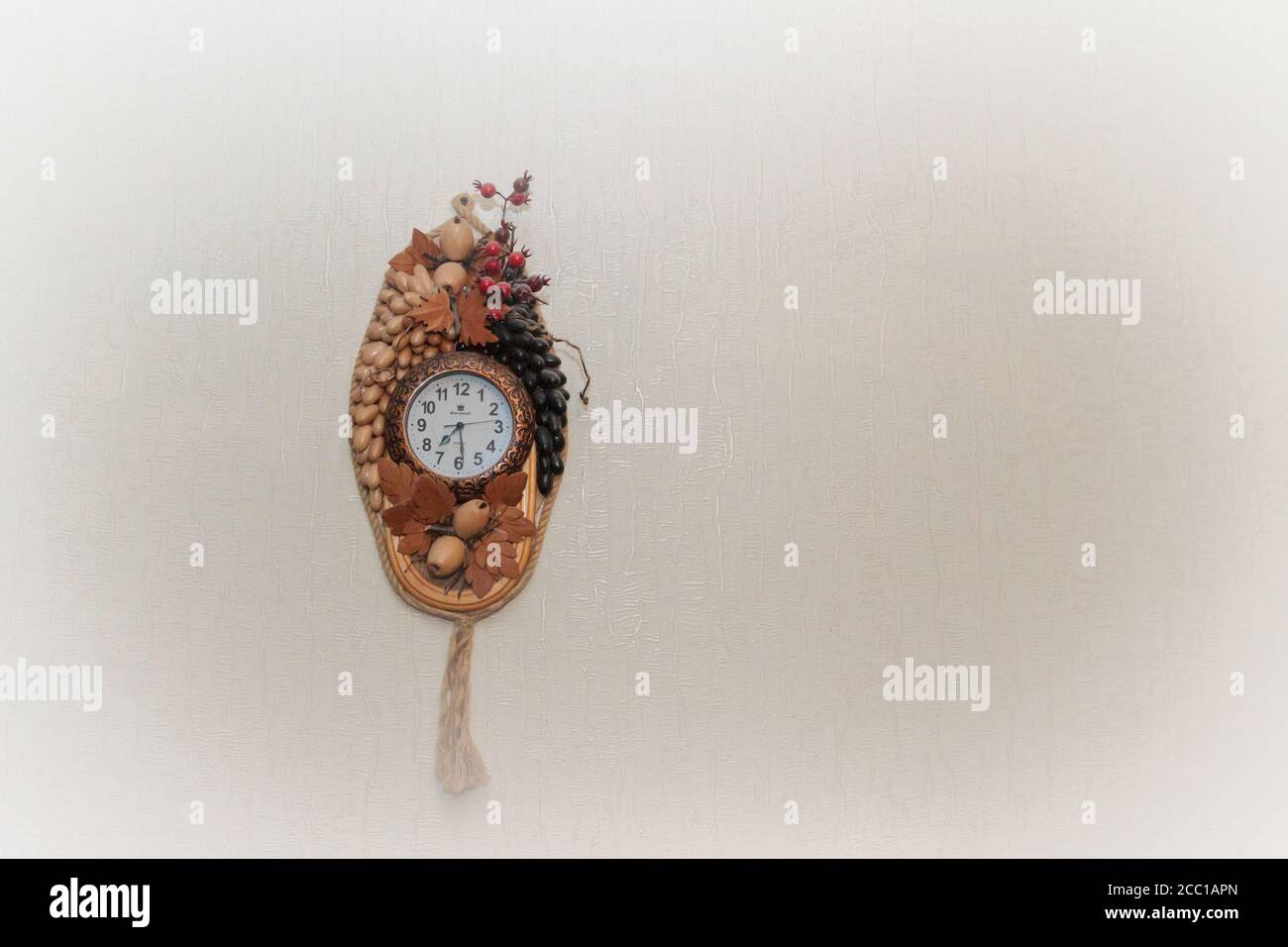 Wall mounted wooden clock hanging on the wall Stock Photo - Alamy