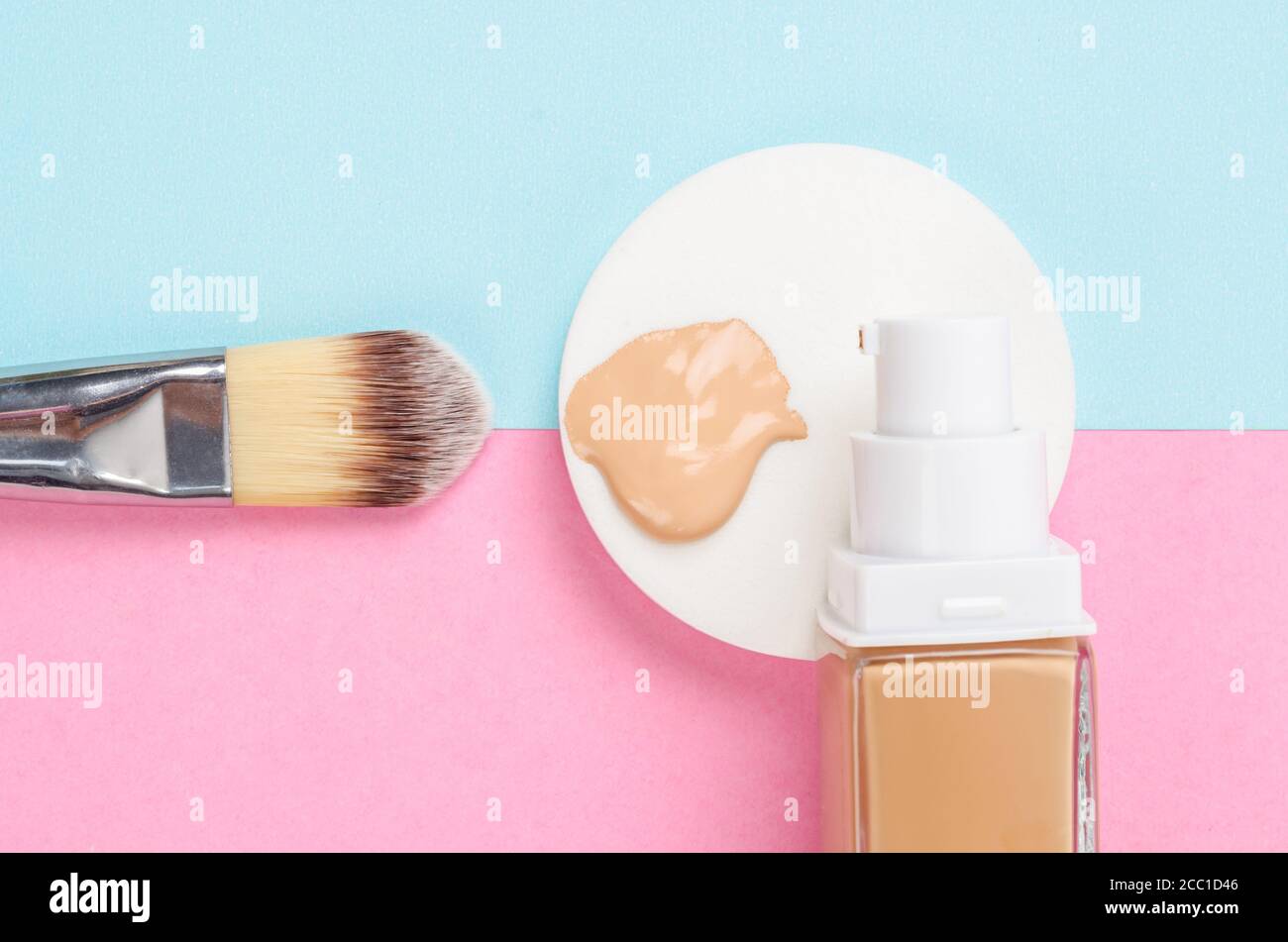 Liquid fluid foundation glass bottle on makeup sponges and egg on pink ...