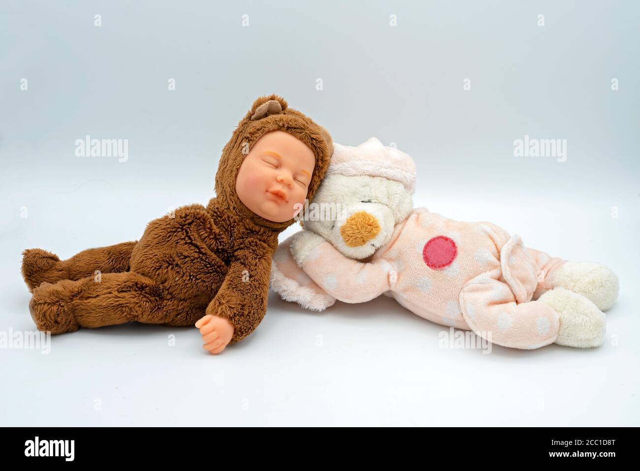 sleeping doll dressed as a teddy bear and a teddy bear Stock Photo - Alamy