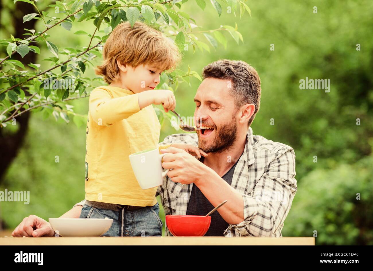 father and son eating outdoor. We like spending time together ...