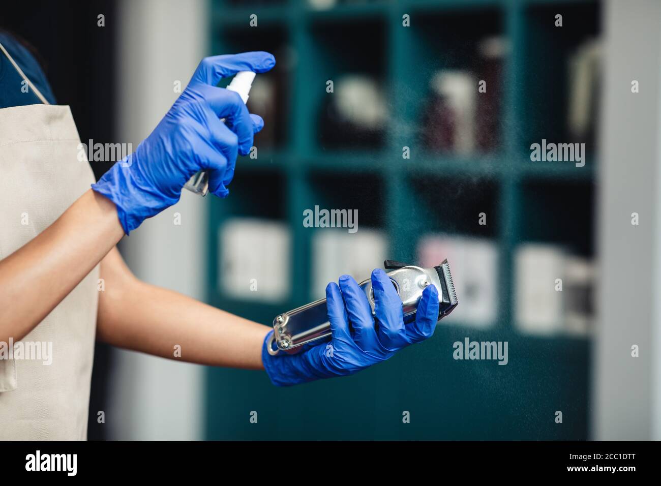 Barber disinfecting trimmer with disinfectant before cutting custome ...
