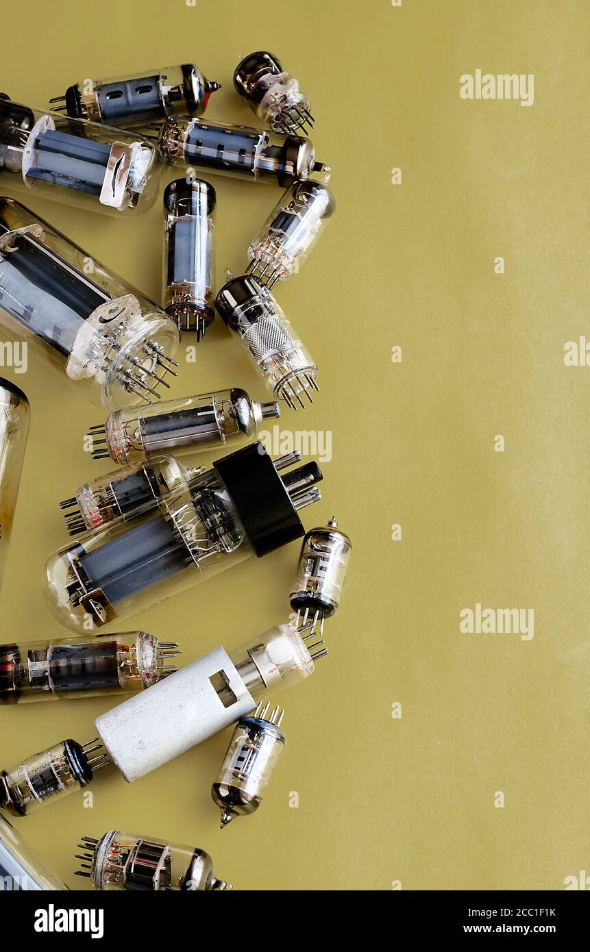 Random vacuum tubes on a yellow background. A group of radio tubes of ...