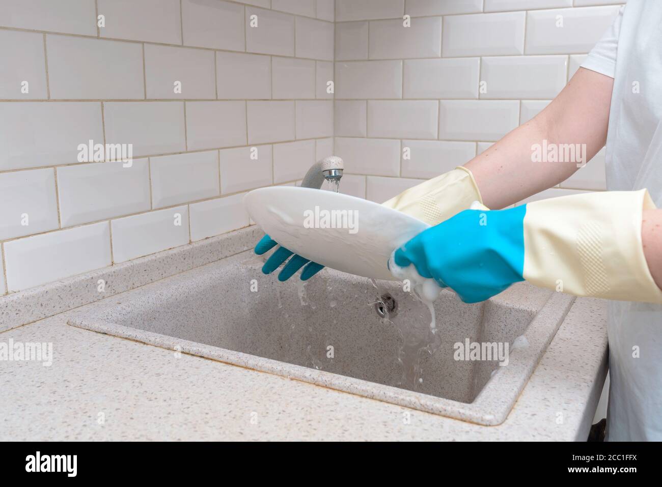 female hands in blue gloves wash a plate in a white kitchen Stock Photo ...
