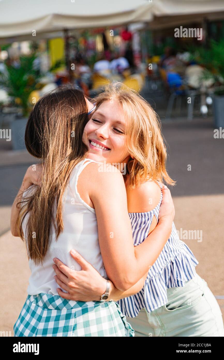 Happy couple or girl friends hugging after meeting Stock Photo - Alamy