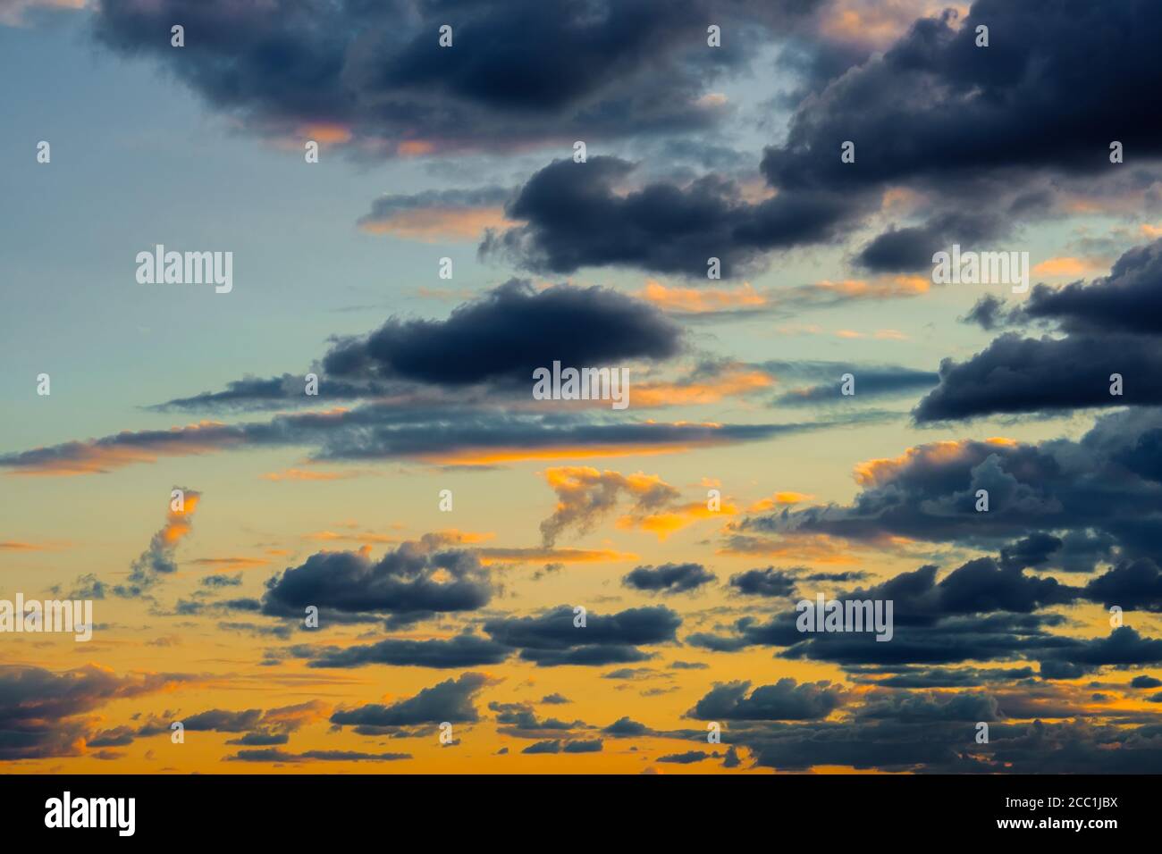 A very dramatic sky full of yellows, blues and oranges. Contrasting ...
