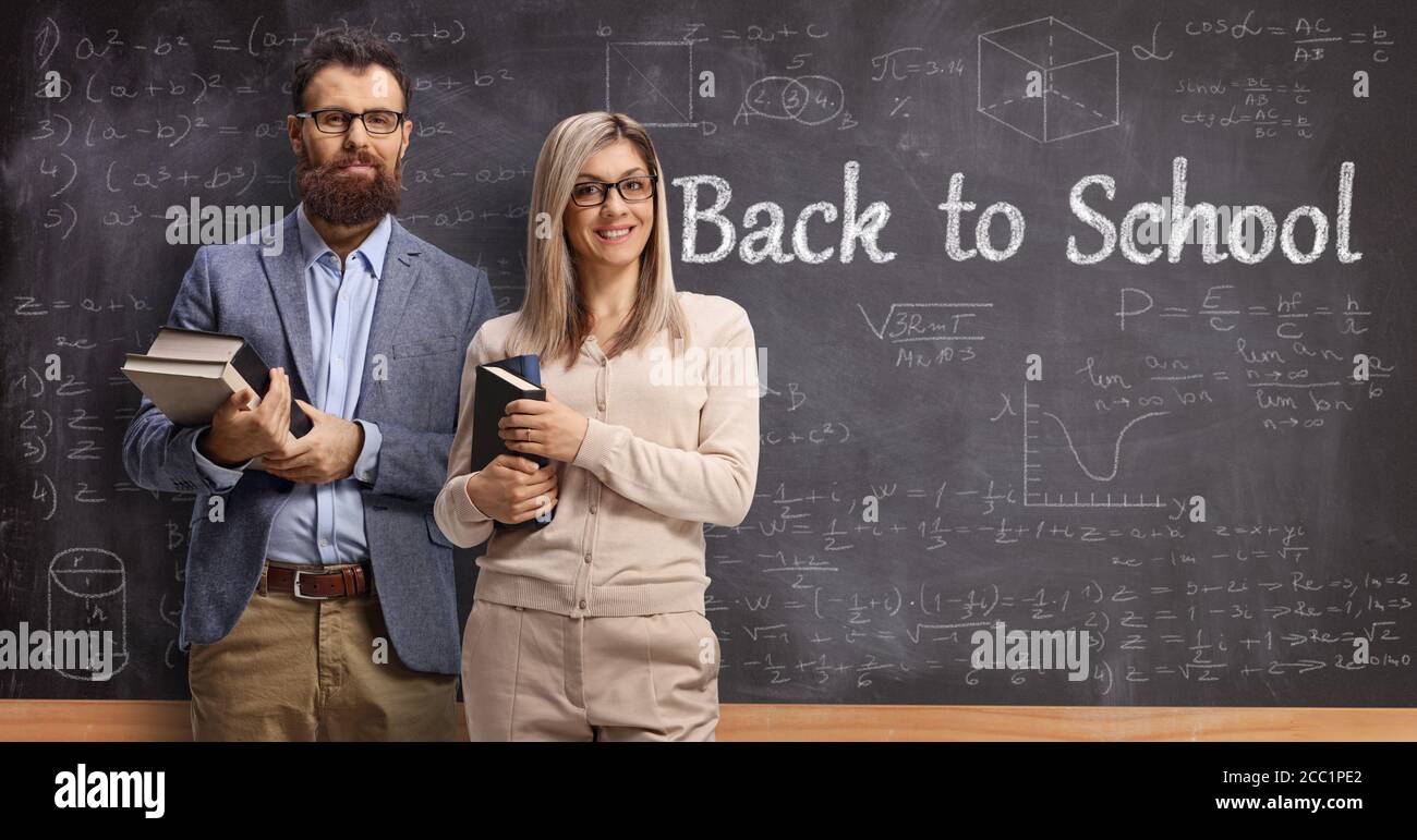 Blackboard with text back to school and male and female teacher ...