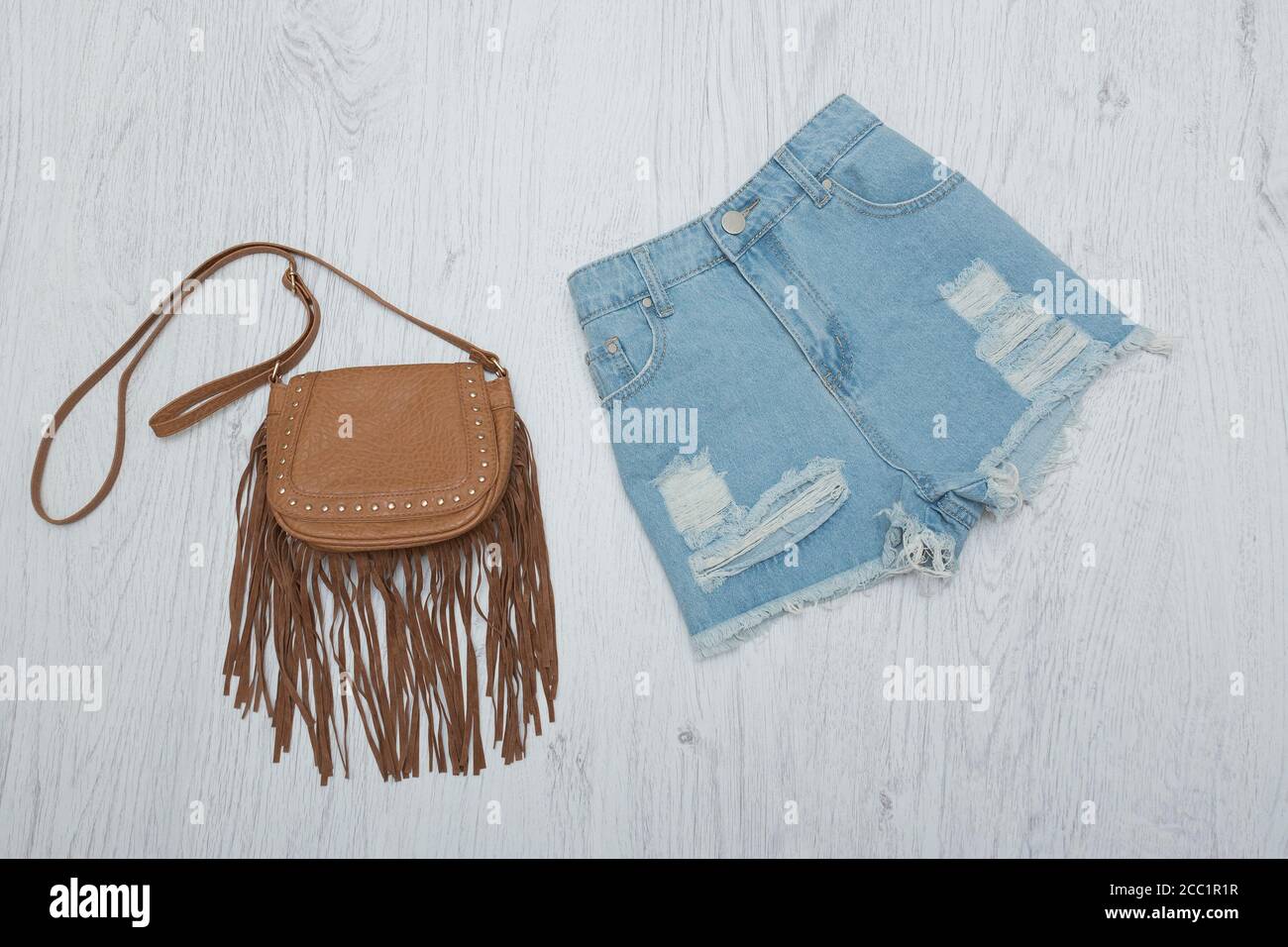 Ragged denim shorts and a brown handbag. Fashionable concept Stock ...