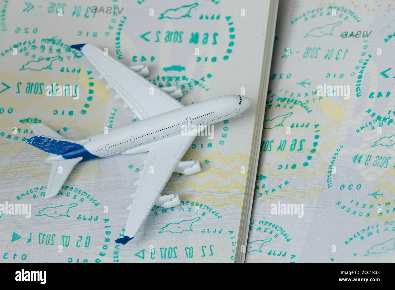 Airplane on passport pages with a visa. Close up Stock Photo - Alamy