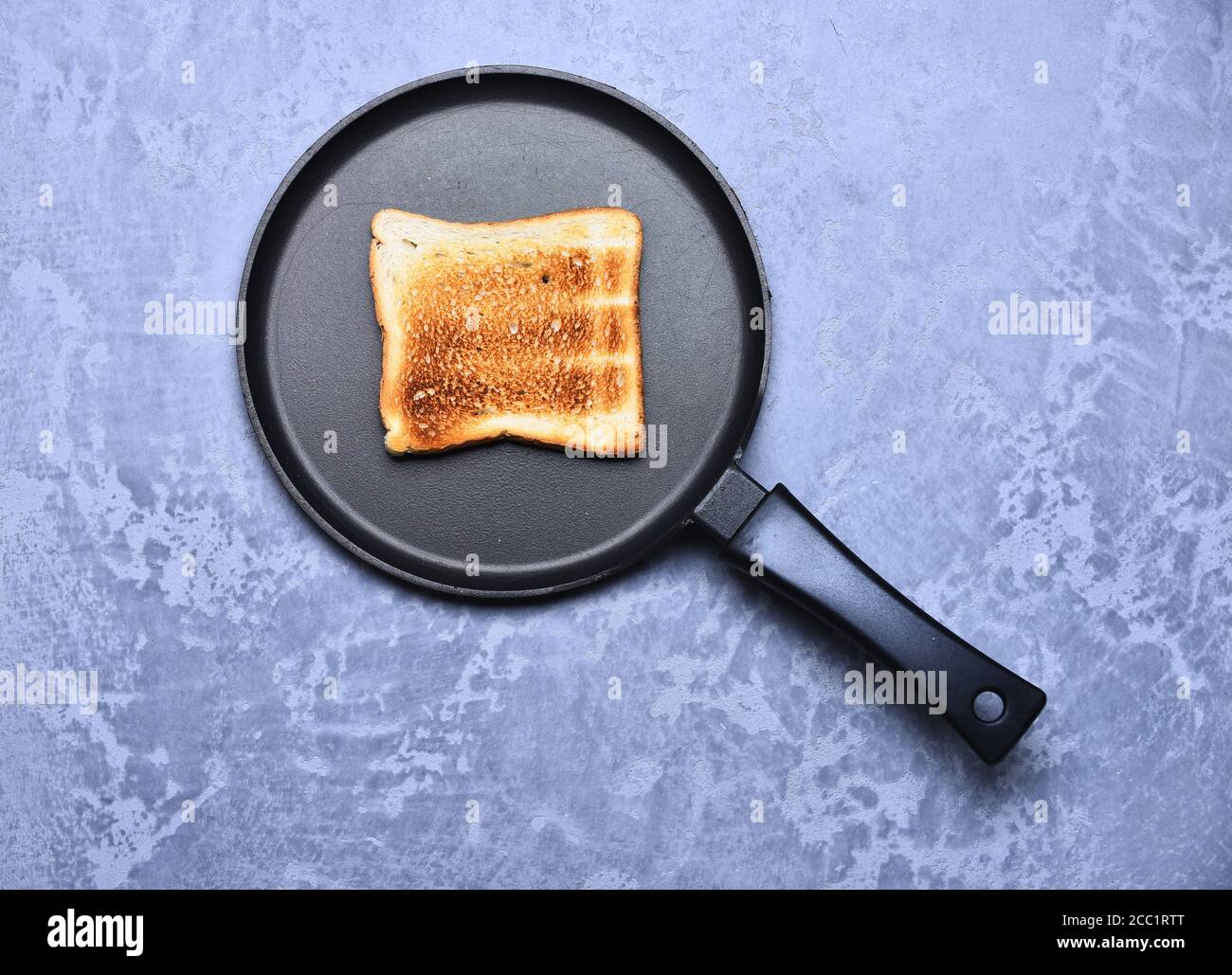 Grilled sandwich cooking in large frying pan on grey background, top ...