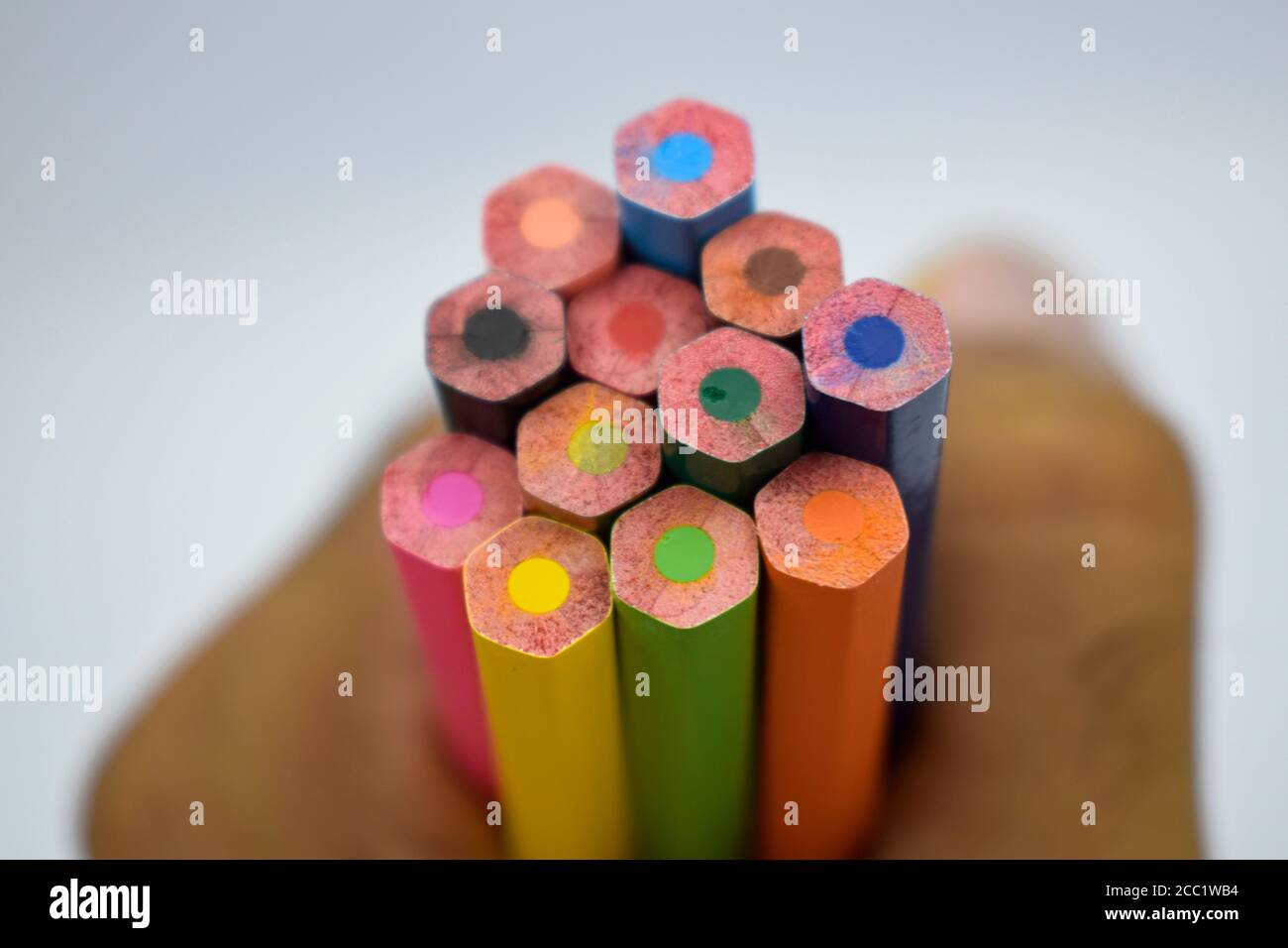 Person holding some different colored wood pencil crayons in his own ...