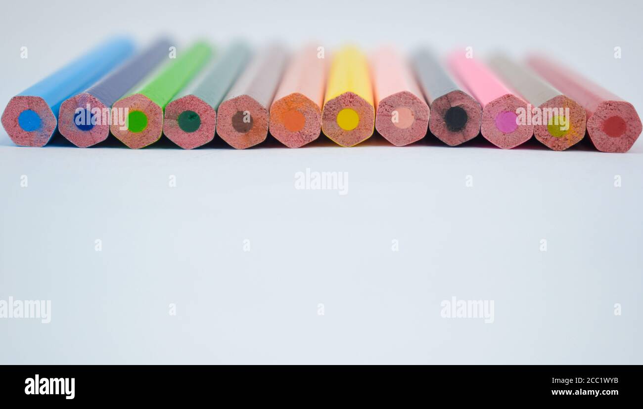 Stack of various colored wood pencil crayons scattered across a white ...