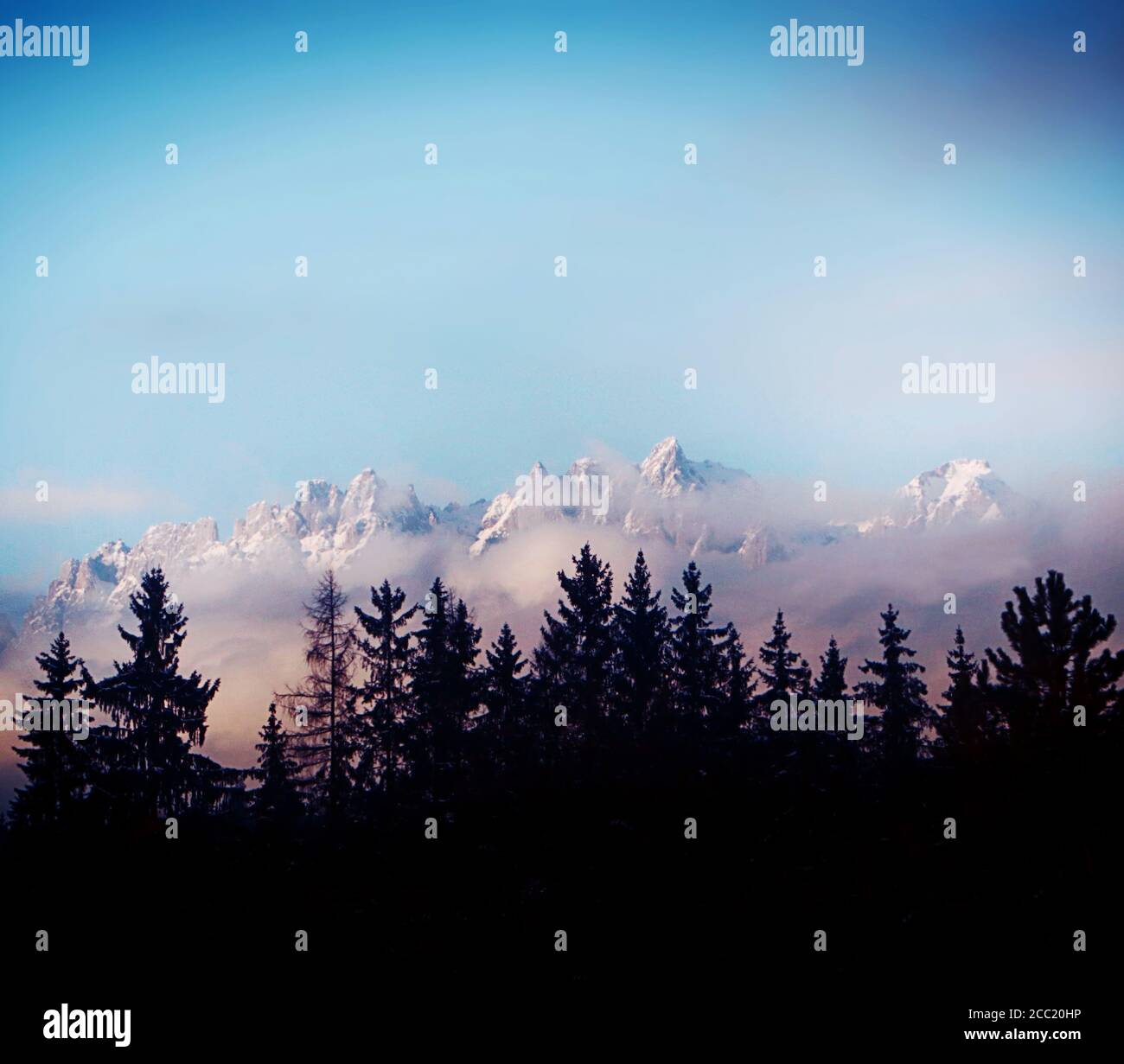 Beautiful view of Austrian Alps surrounded by lower clouds behind a ...