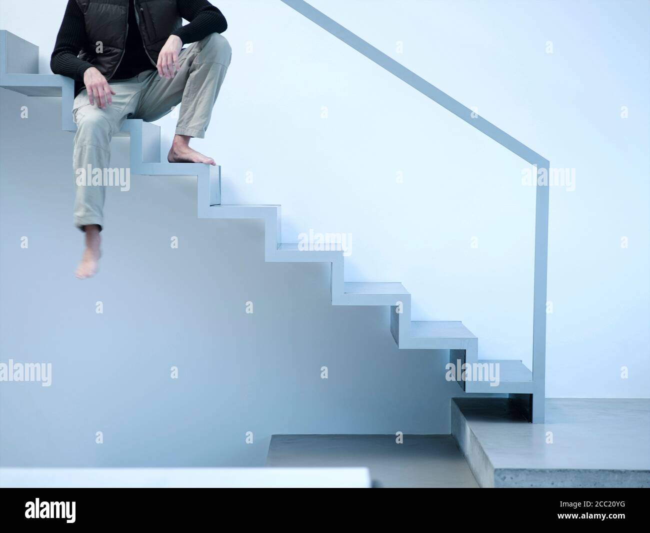 Man sitting on stairs Stock Photo - Alamy