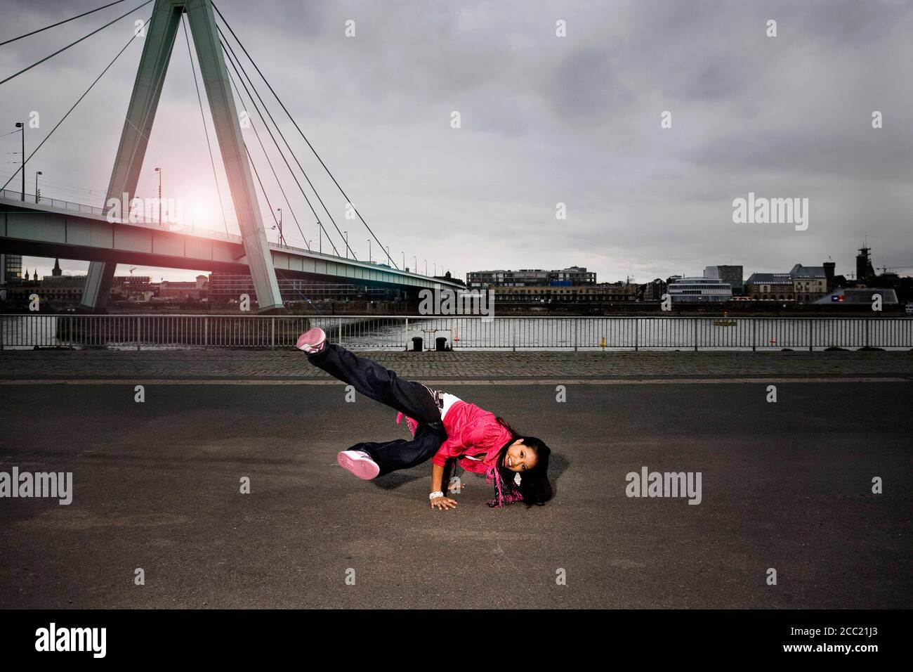 Germany, Cologne, Young woman performing break-dance, portrait Stock ...