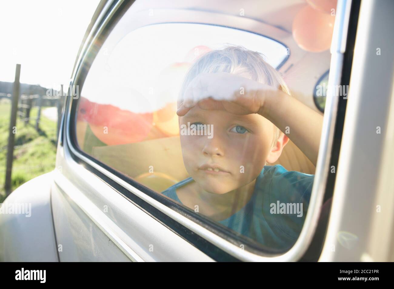 Germany, North Rhine Westphalia, Cologne, Boy in car looking through ...
