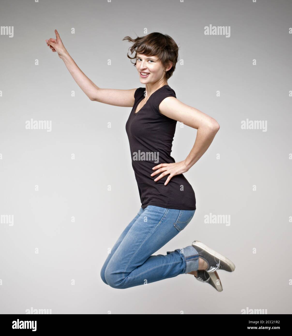 Woman jumping on grey background hi-res stock photography and images ...