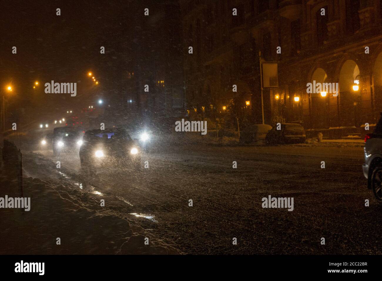 Winter snow storm. Traffic jam at night. Car blurred at the street ...