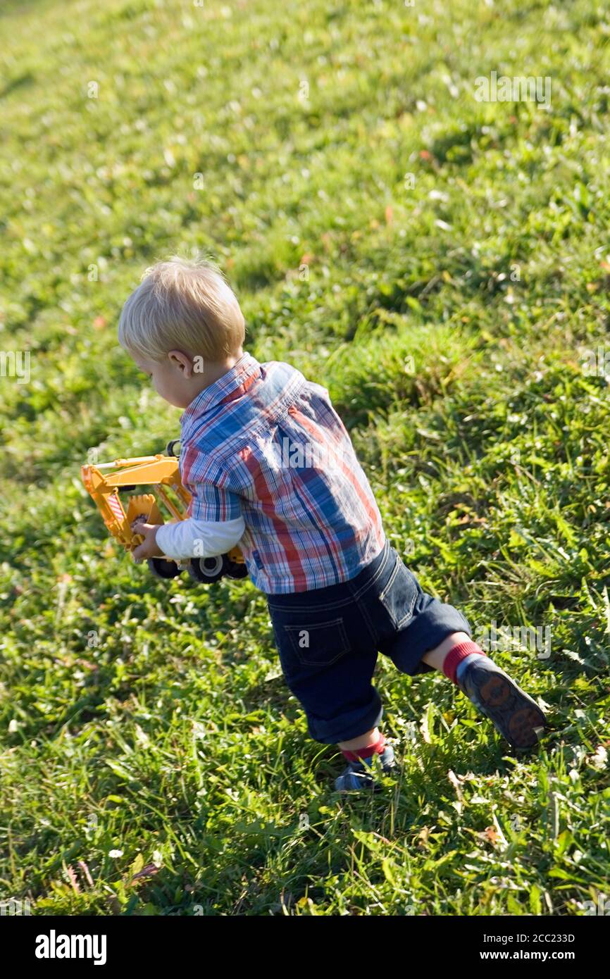 Little boy (2-3) playing with toy car, rear view Stock Photo - Alamy