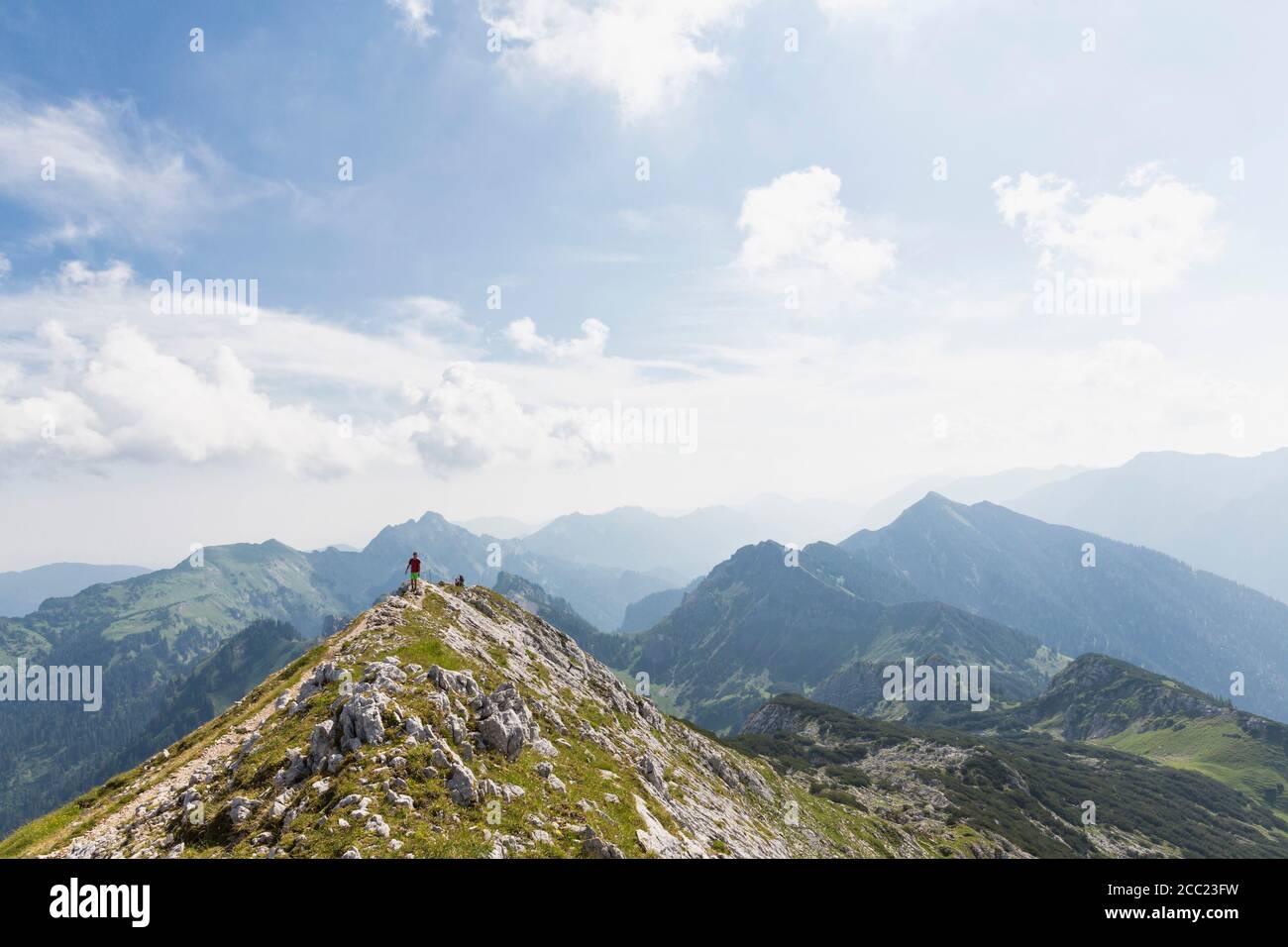 Germany, Bavaria, Ammergau Alps, View of hiker on ridge walk to ...