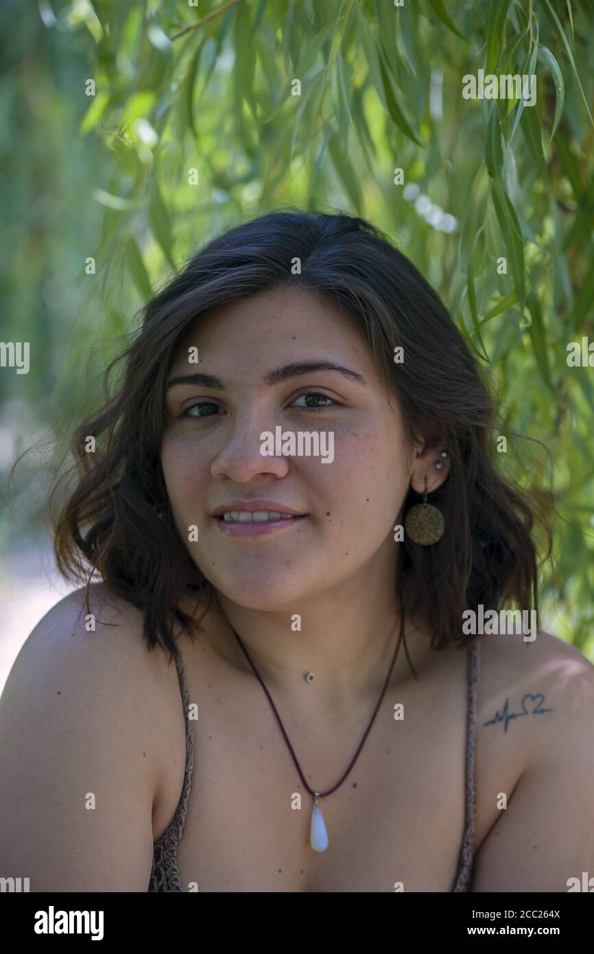 Portrait of a woman under a willow tree with green leaves Stock Photo ...