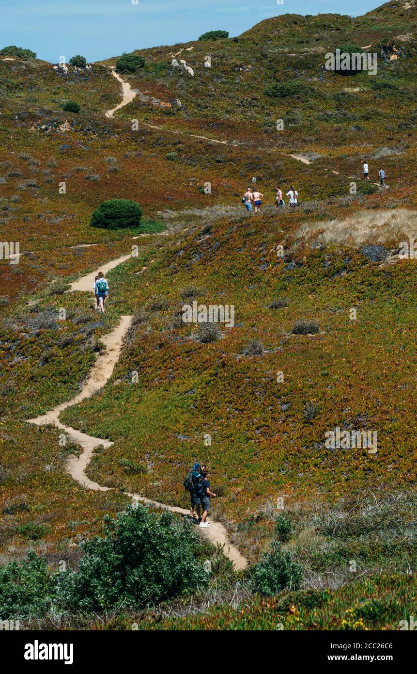 Tourists enjoying hiking steep trails at Cabo da Roca, Sintra, Portugal ...