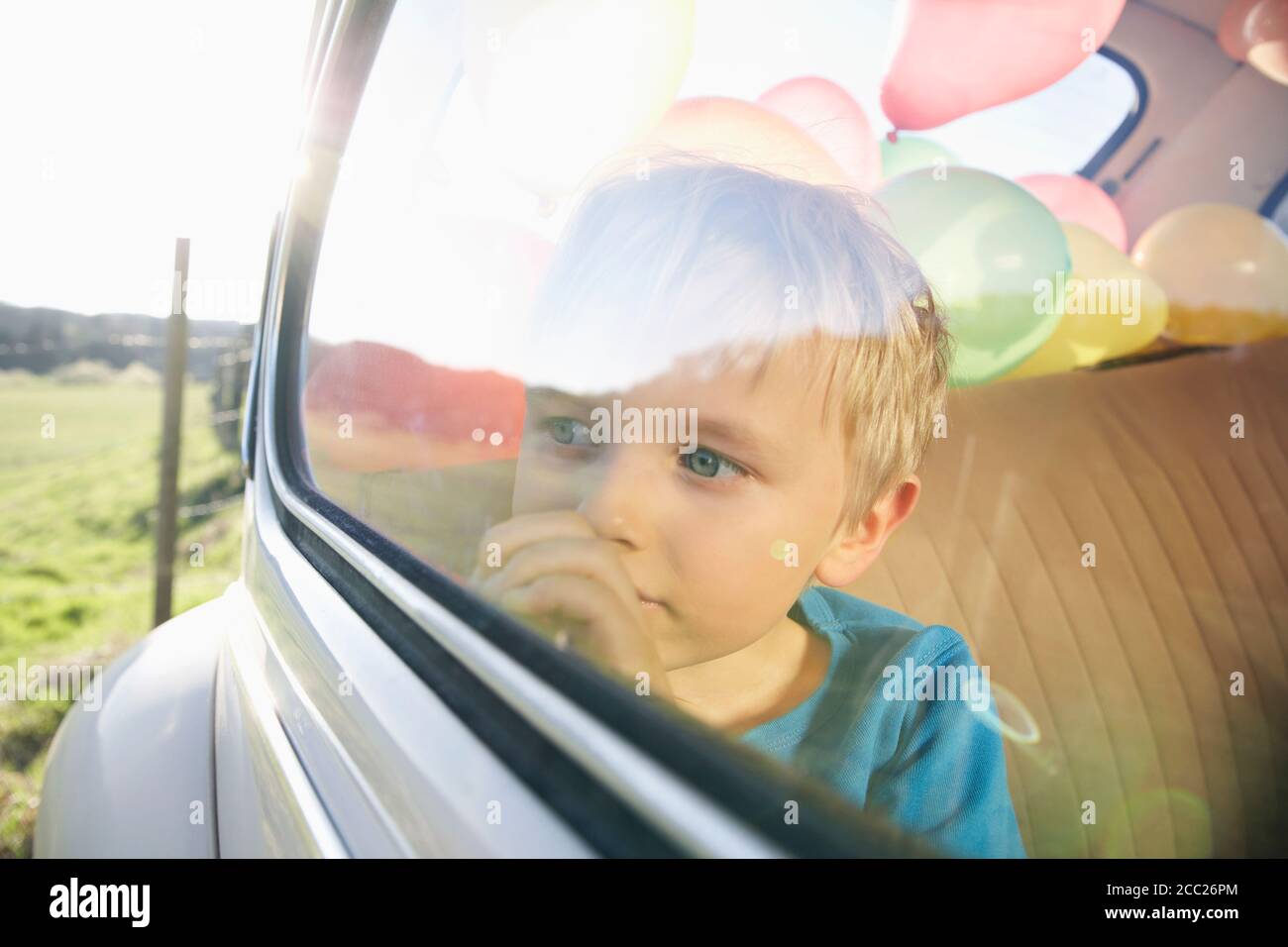 Germany, North Rhine Westphalia, Cologne, Boy in car looking through ...