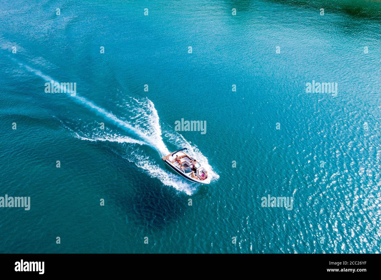 An aerial overhead view of a boat cruising on the beautiful, blue ...