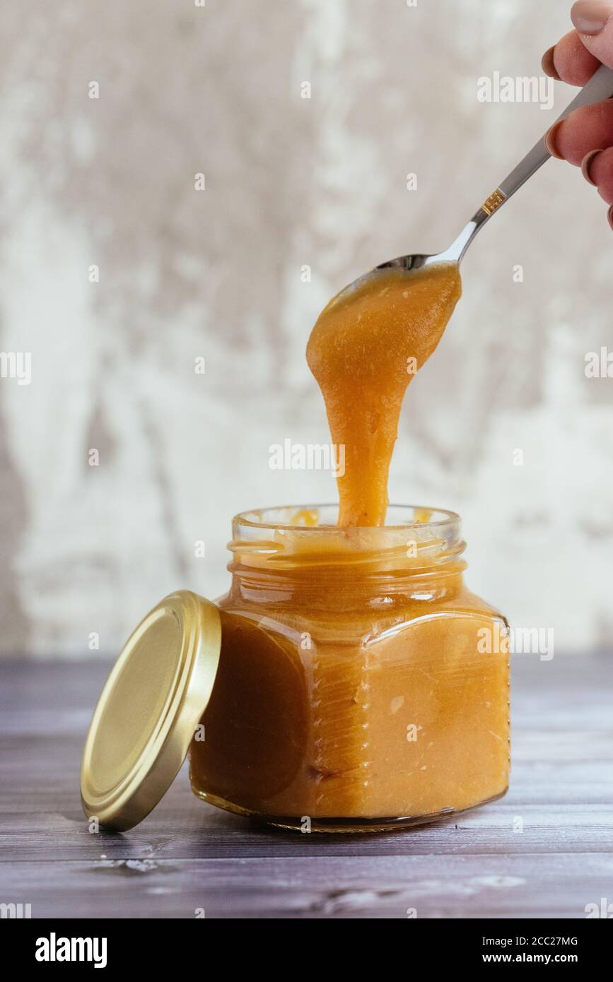 homemade caramel in a jar with a spoon Stock Photo - Alamy