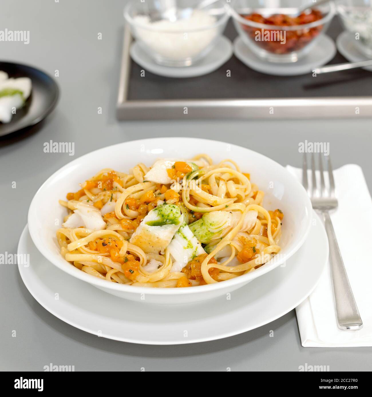 Pasta with papaya, fish and green sauce, close-up Stock Photo - Alamy