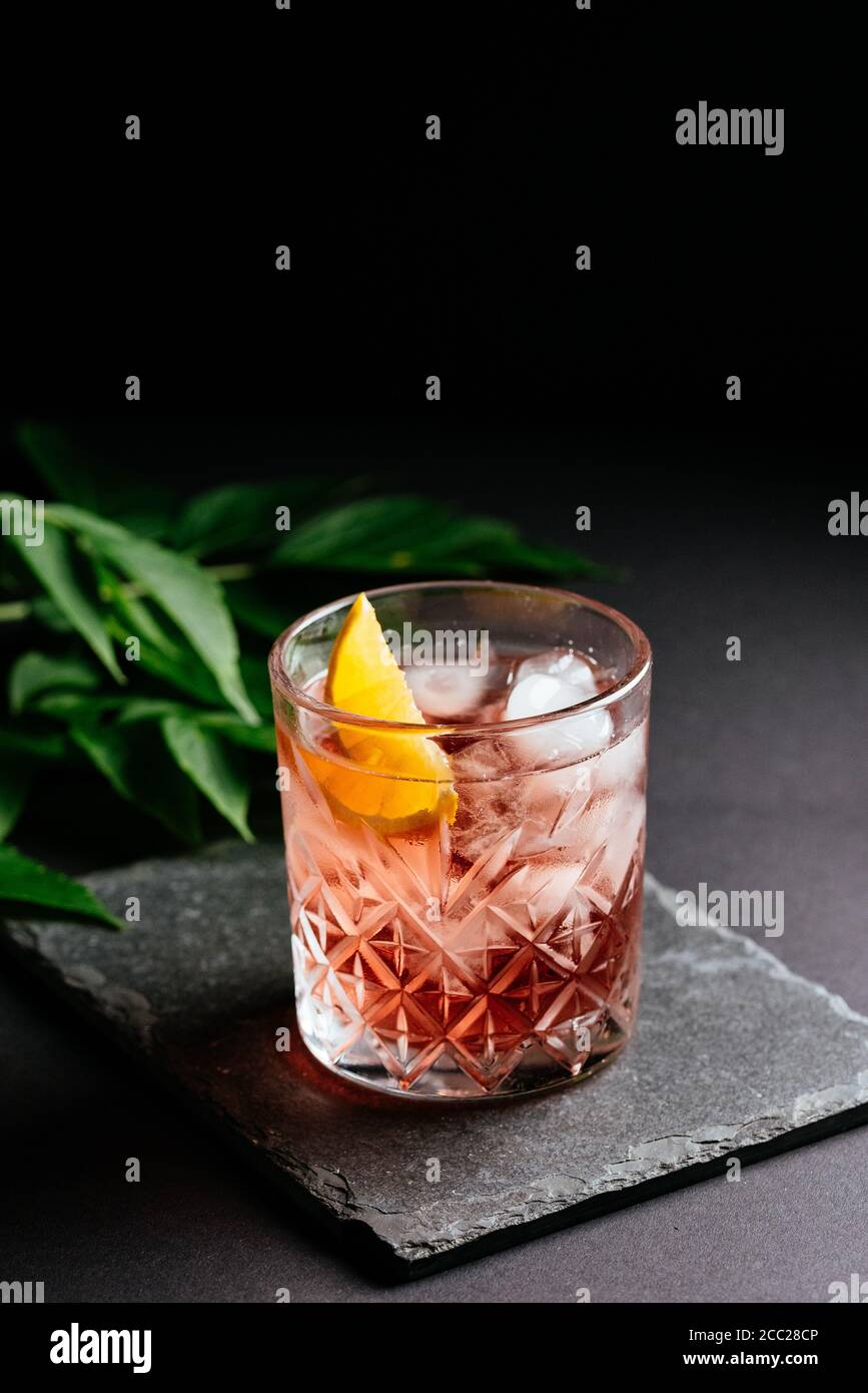 glass of alcoholic coctail with ice on black background Stock Photo - Alamy